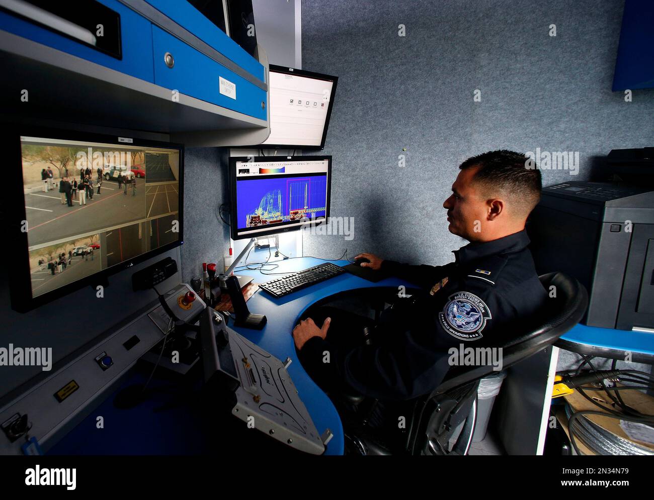 A U.S. Customs and Border Protection agent sits in a control booth as ...