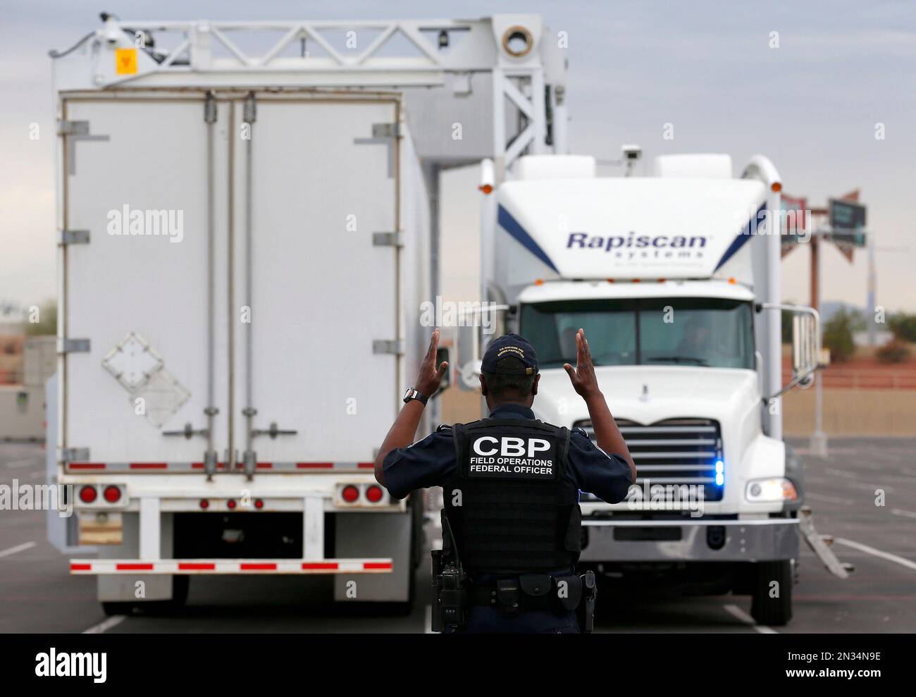 A U.S. Customs and Border Protection agent waves a truck-sized X-ray ...