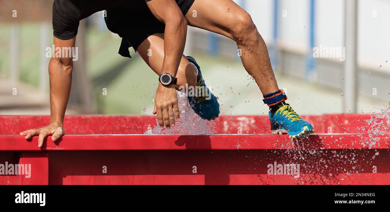 Man overcomes water obstacle on obstacle course. Mud race runners Stock ...