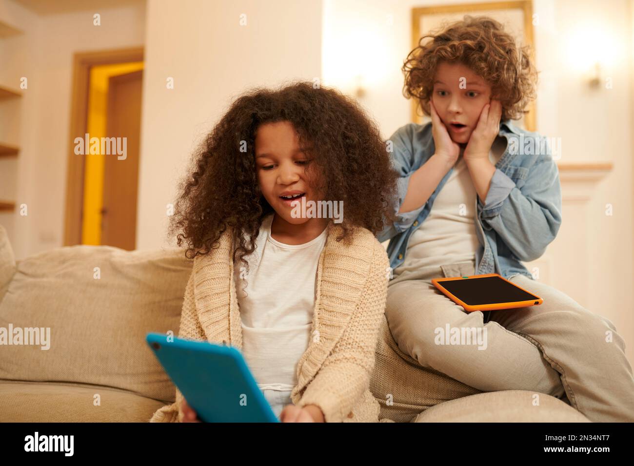 A boy and a girl with devices watching something online Stock Photo - Alamy