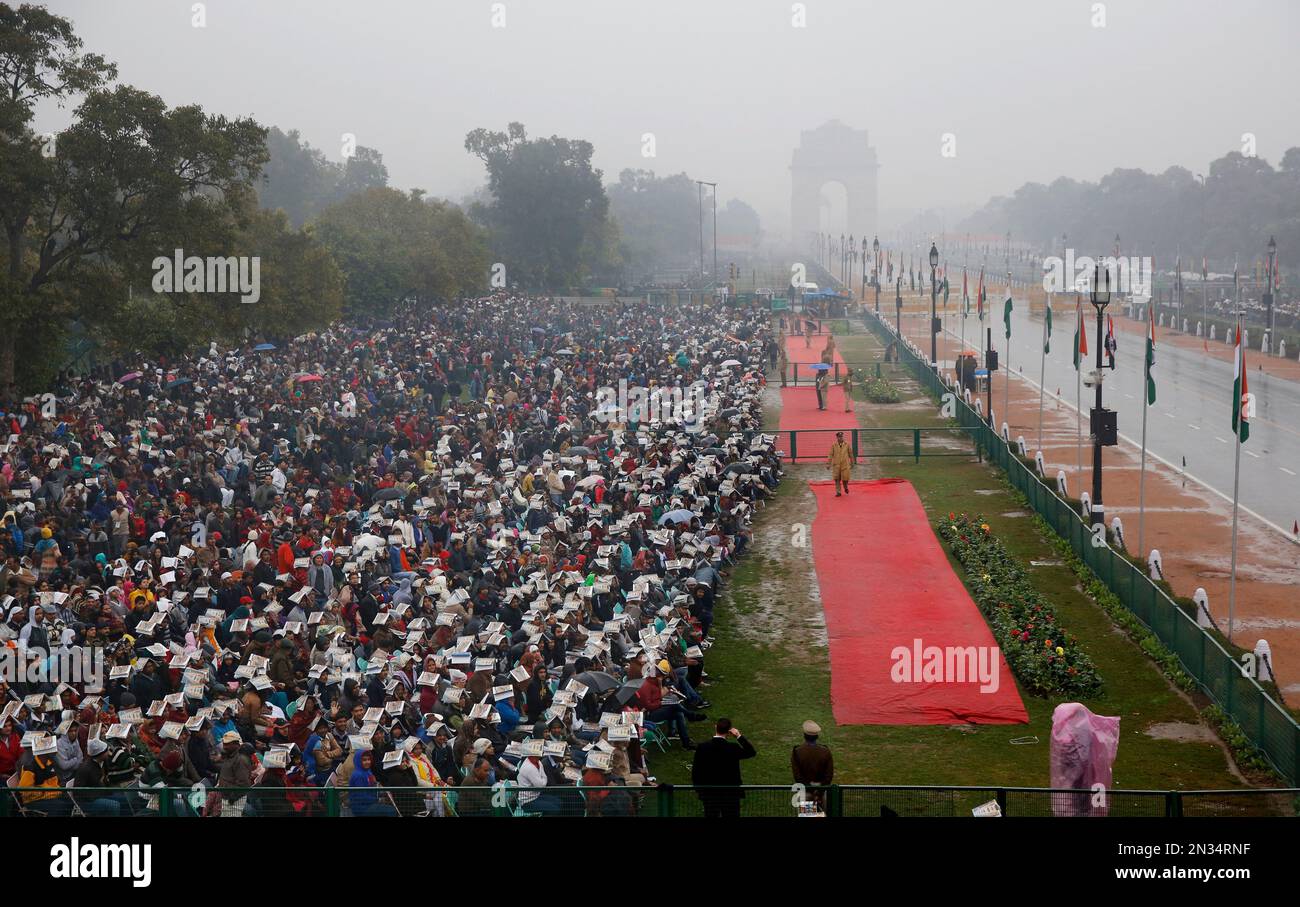 A crowd gathers to watch Republic Day parade as it rains in New Delhi ...