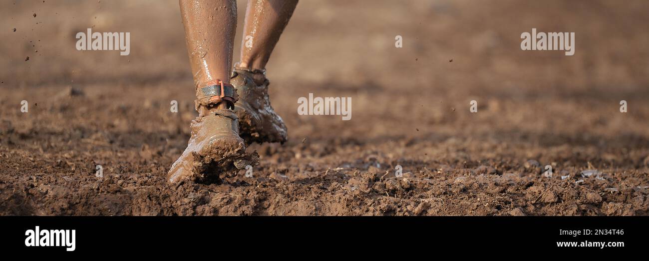 Mud race runners detail of the legs, muddy running shoes a run in the ...