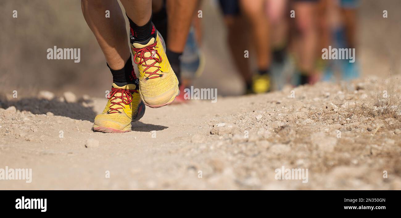 Group of young adults competition and running together through trails ...