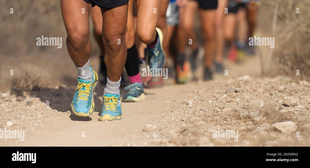 Group of young adults competition and running together through trails ...