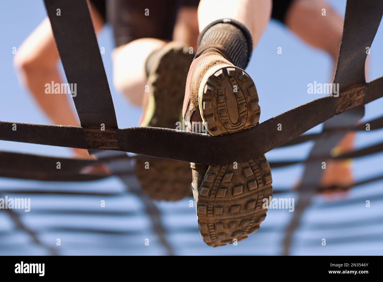 Athlete climbs the net, climbing net in an obstacle course. Look from ...