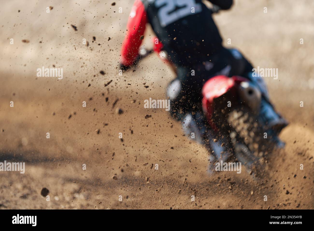 Motocross rider creates a huge cloud of dust and stone, flying debris ...