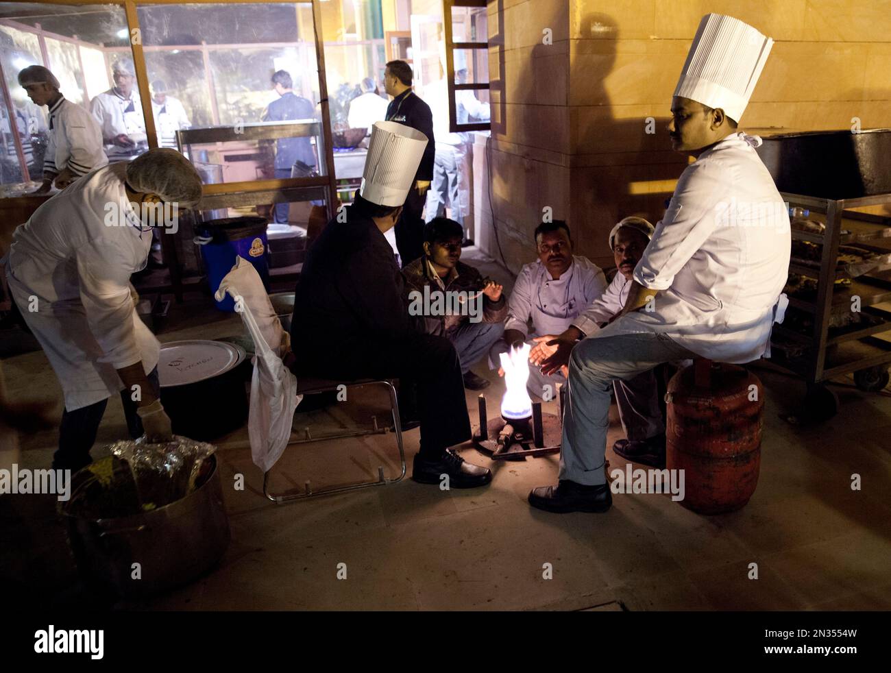 Kitchen workers gather round a warm flame outside the Rashtrapati ...