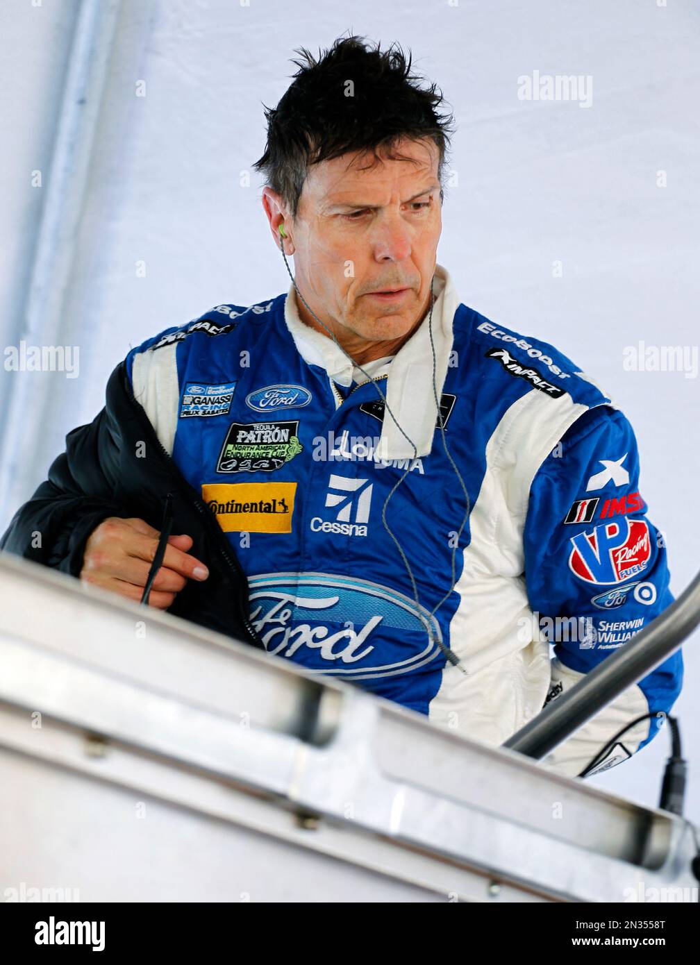 Scott Pruett puts on his jacket in his pit stall after his turn driving ...
