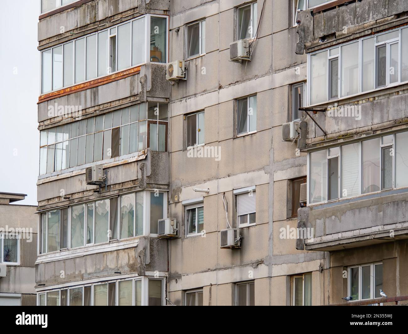 Worn out apartment building from the communist era against blue sky in ...