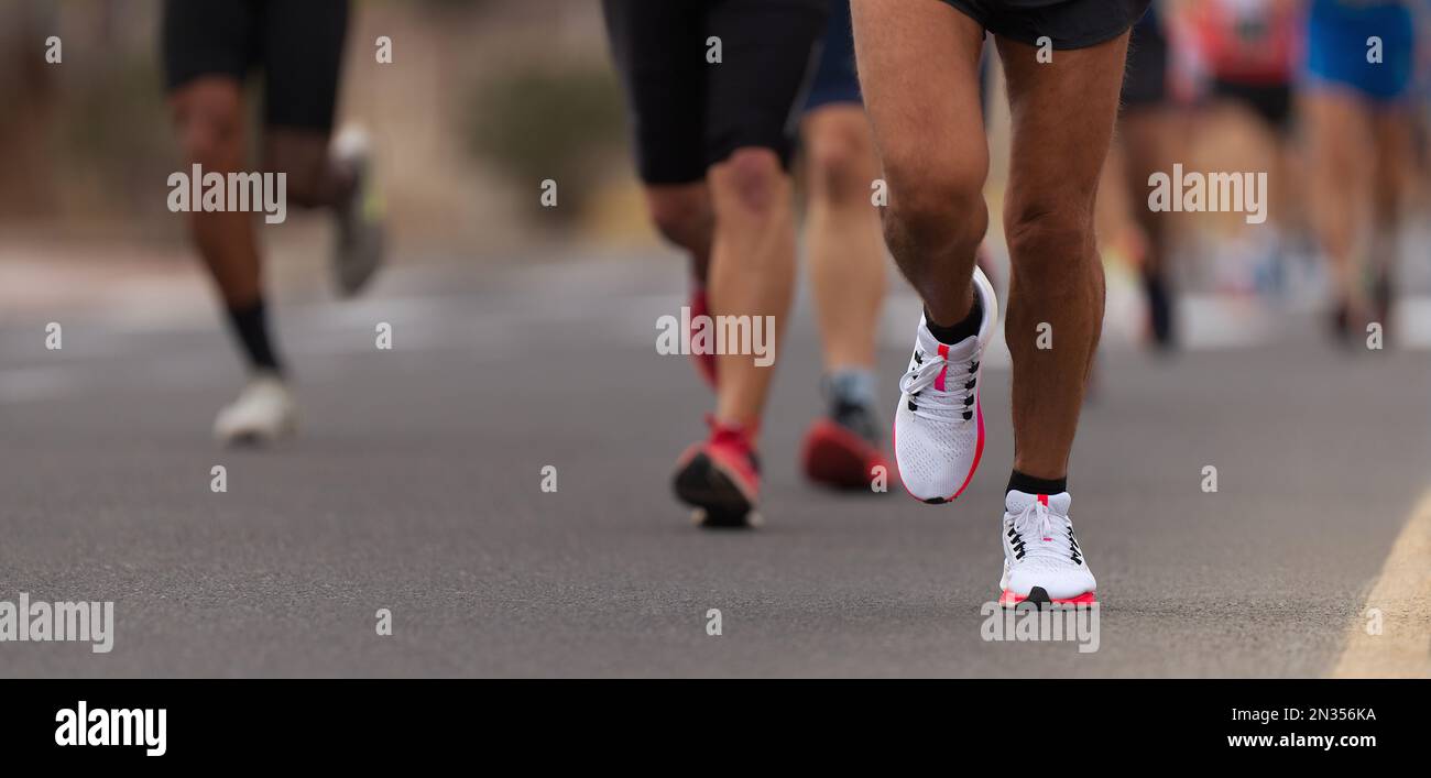 Marathon running race, people feet on city road, runners run urban ...