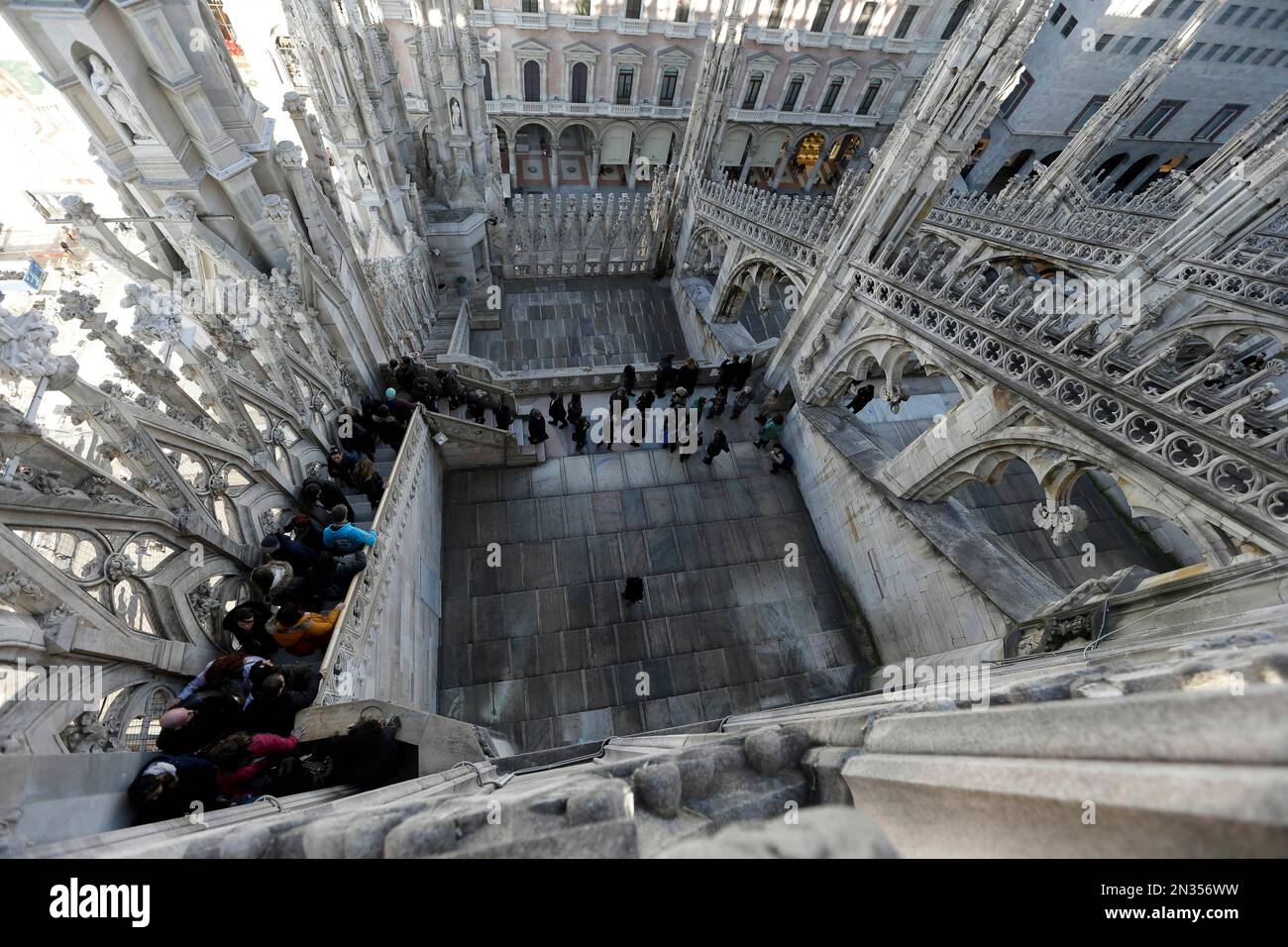 Tourists and visitors climb to watch the roof of the Duomo gothic ...
