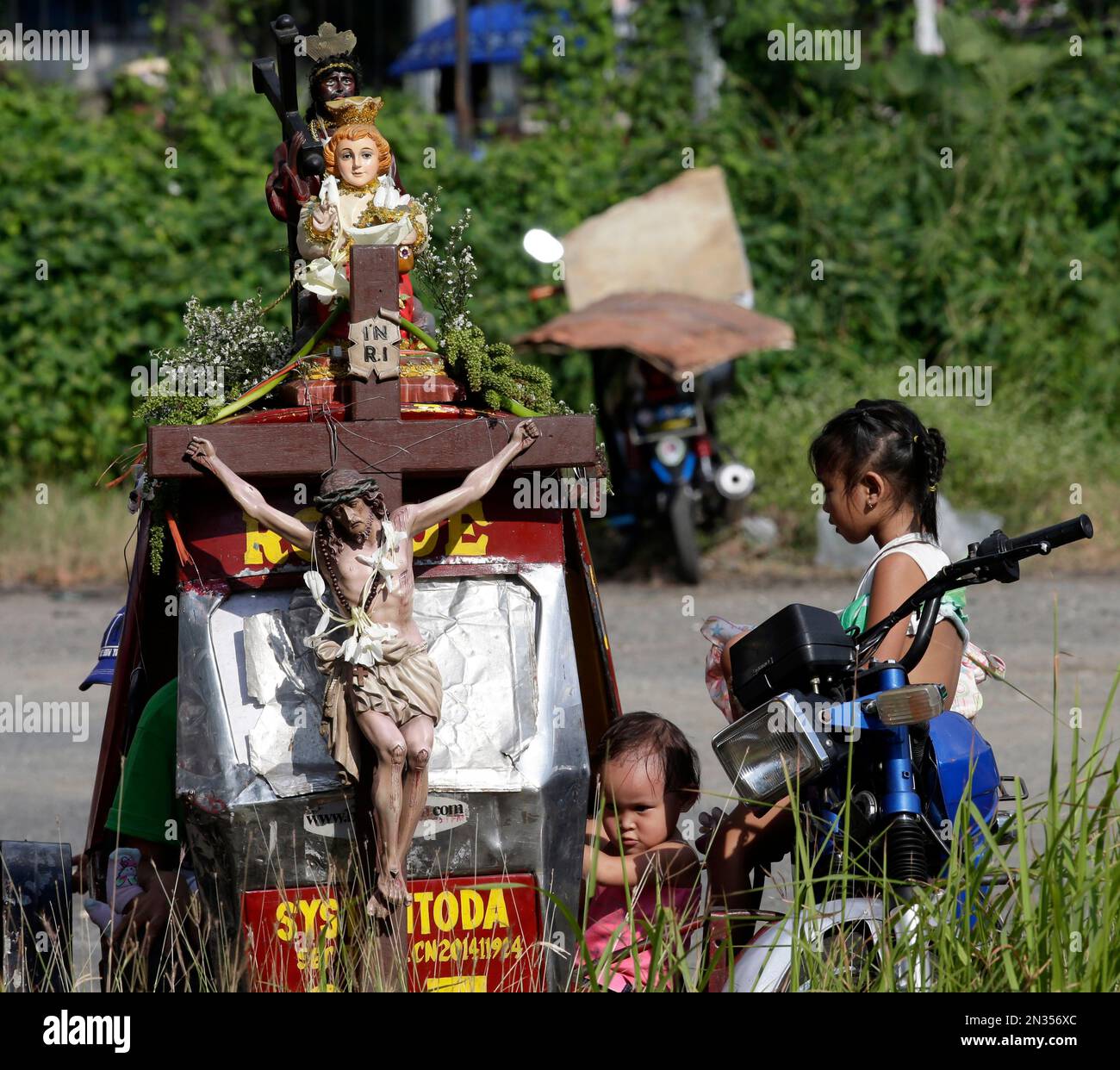 A family waits for their turn to join a procession of hundreds of ...