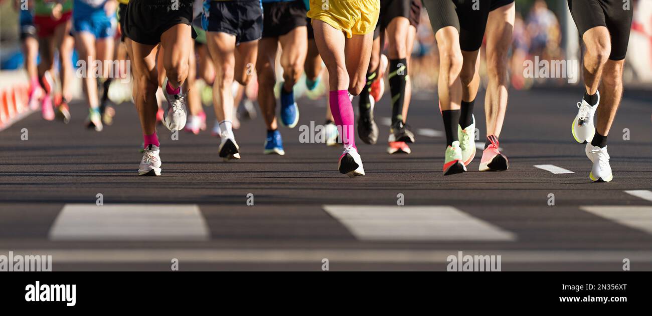 Marathon runners running on city road, large group of runners Stock ...