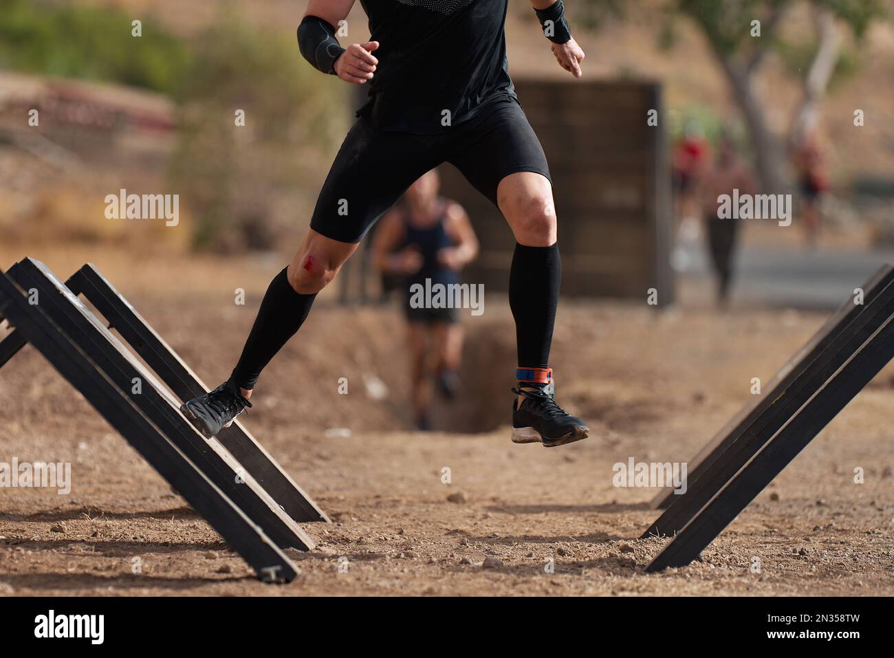 Mud race runners during extreme obstacle race Stock Photo - Alamy