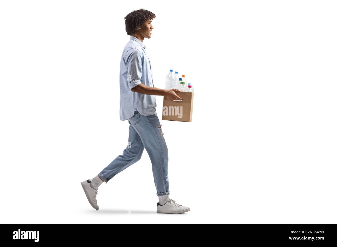 Full length profile shot of a young african american man carrying a box ...