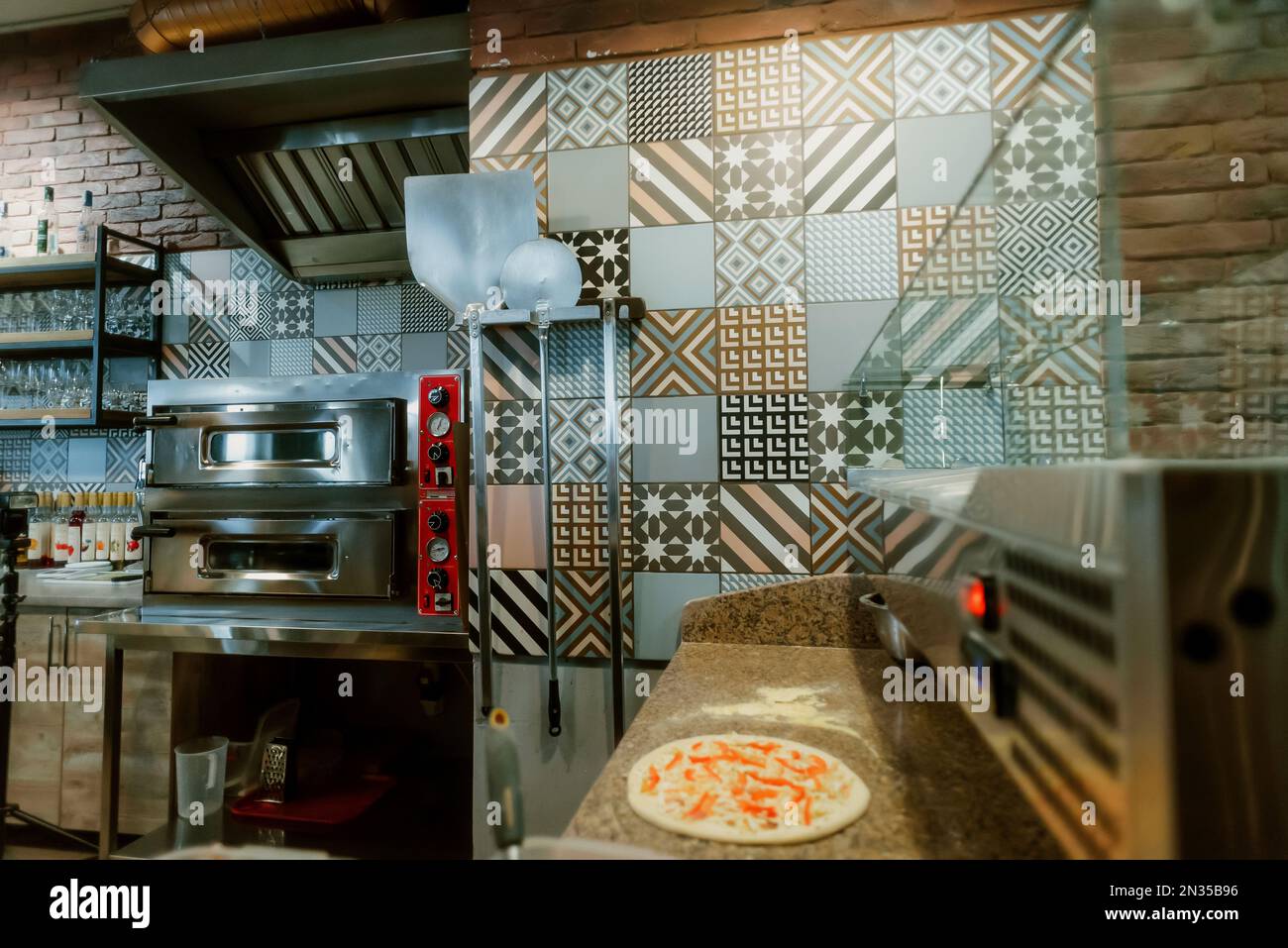 Pizza tools hang on the wall next to the oven. Cafe interior ...