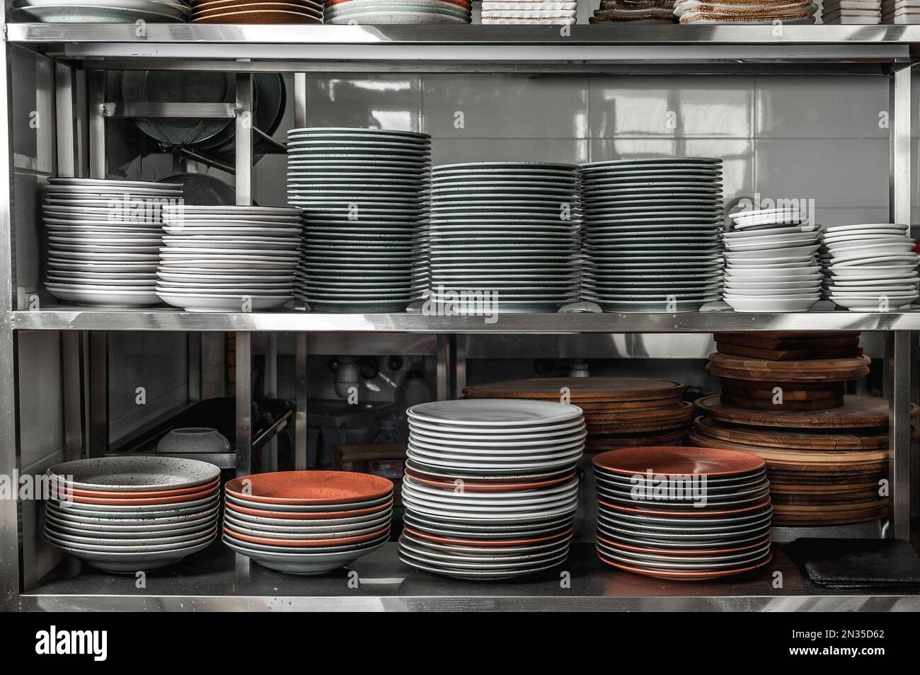 Clean dishes in the restaurant on the shelves. Multicolored plates in ...