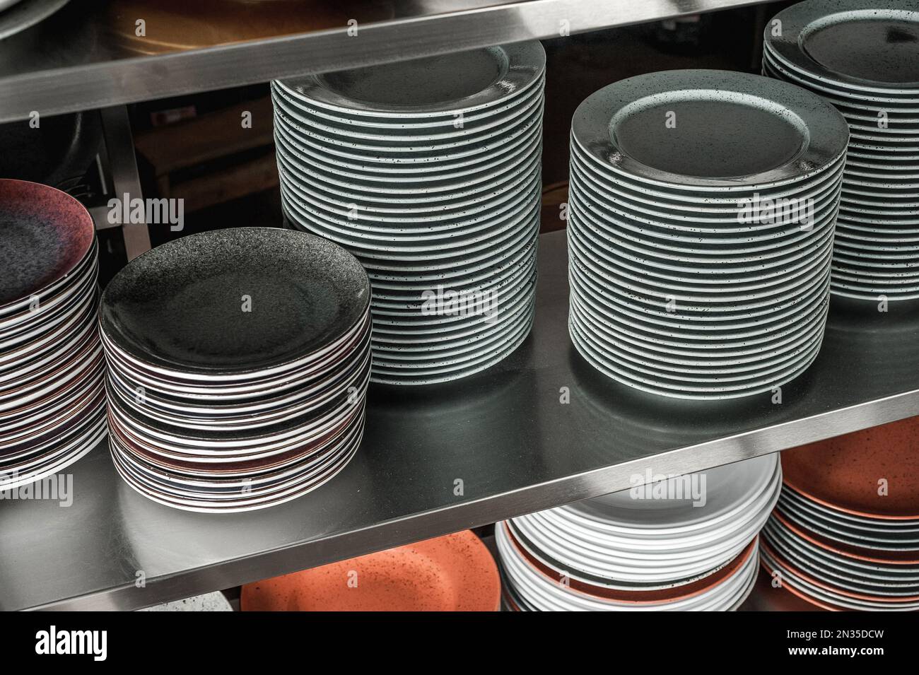 Clean dishes in the restaurant on the shelves. Multicolored plates in ...