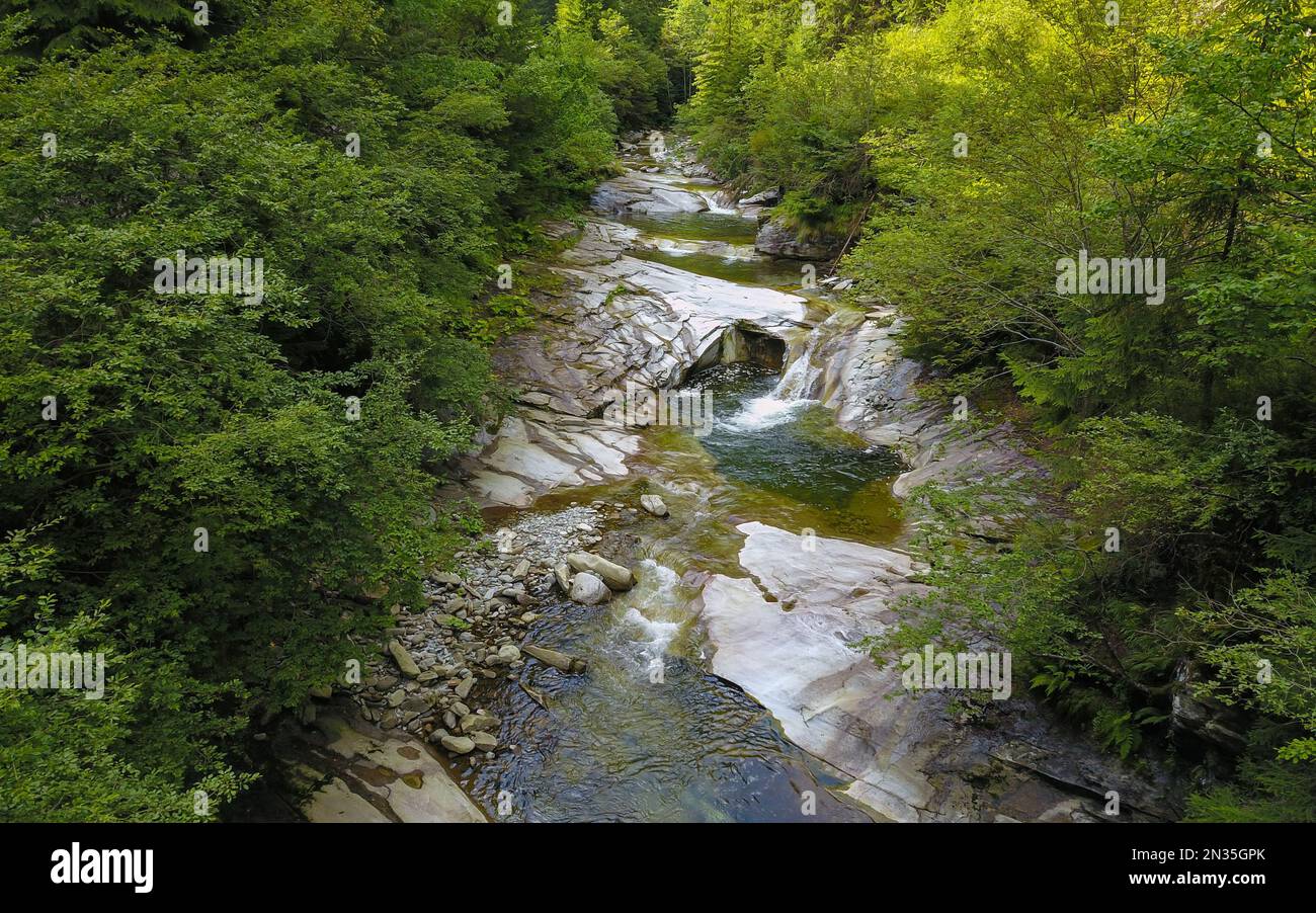 Drone photo above a mountain river forming stepped cascades and ponds ...