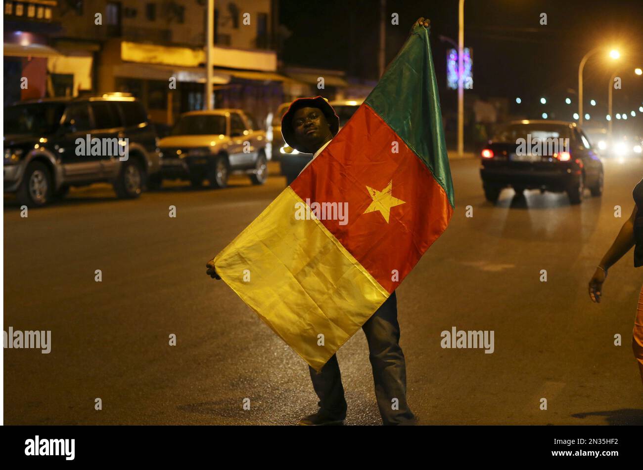 A Cameroon soccer supporter display a Cameroonian flag on the street ...