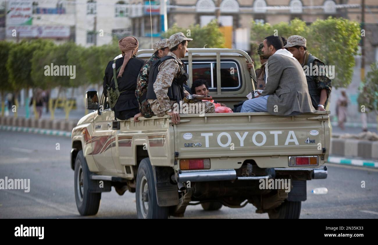 Houthi Shiite fighters wearing an army uniform ride on a pickup truck ...