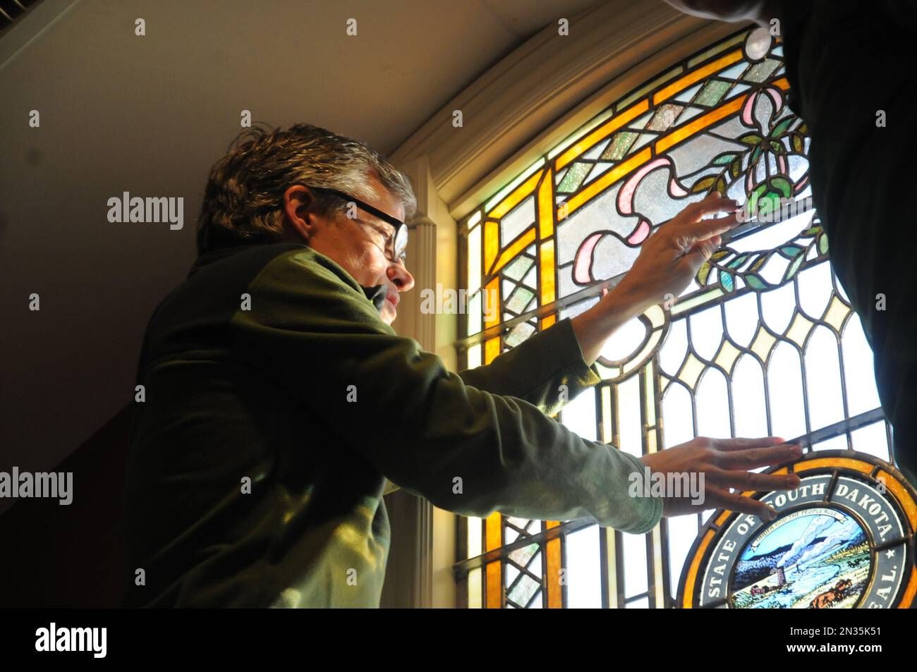 Kevin Grabowski, left, of Conrad Schmitt Studios installs a stained ...