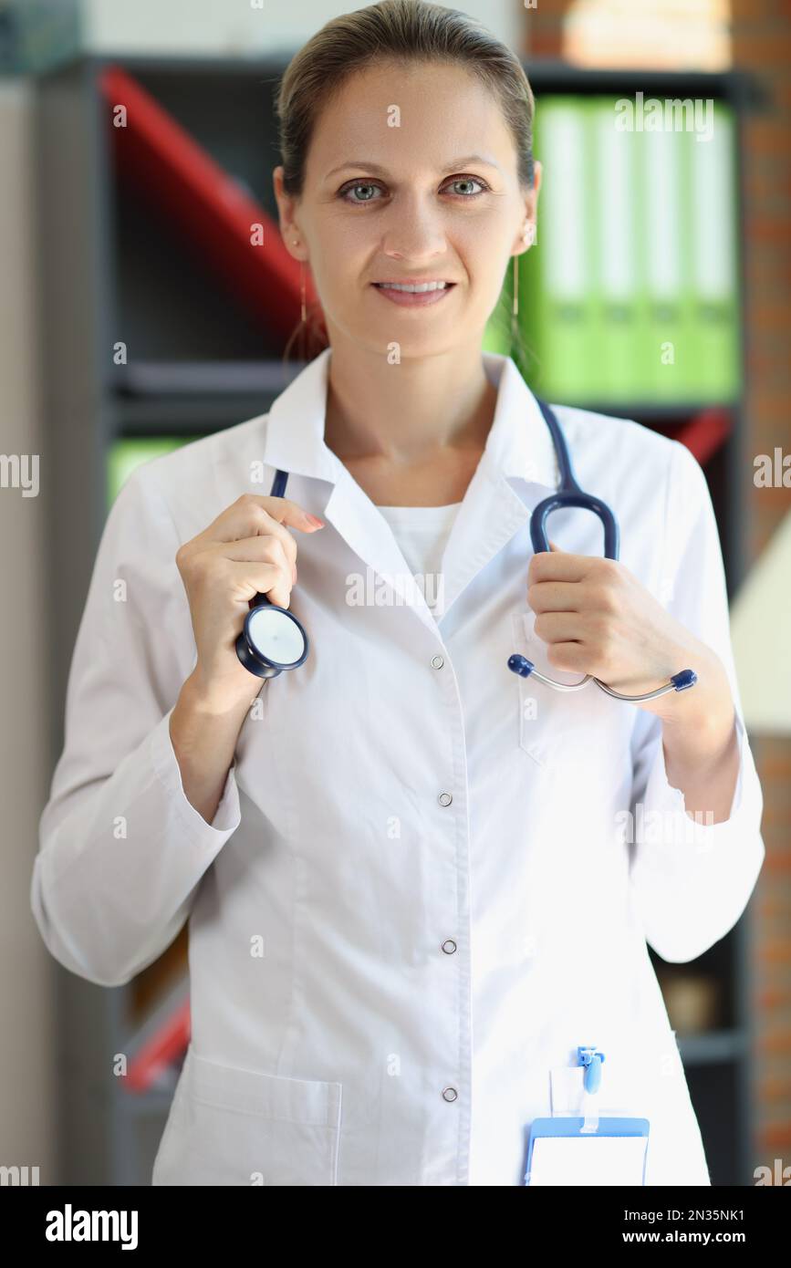Smart female doctor holding stethoscope and looking at camera Stock ...