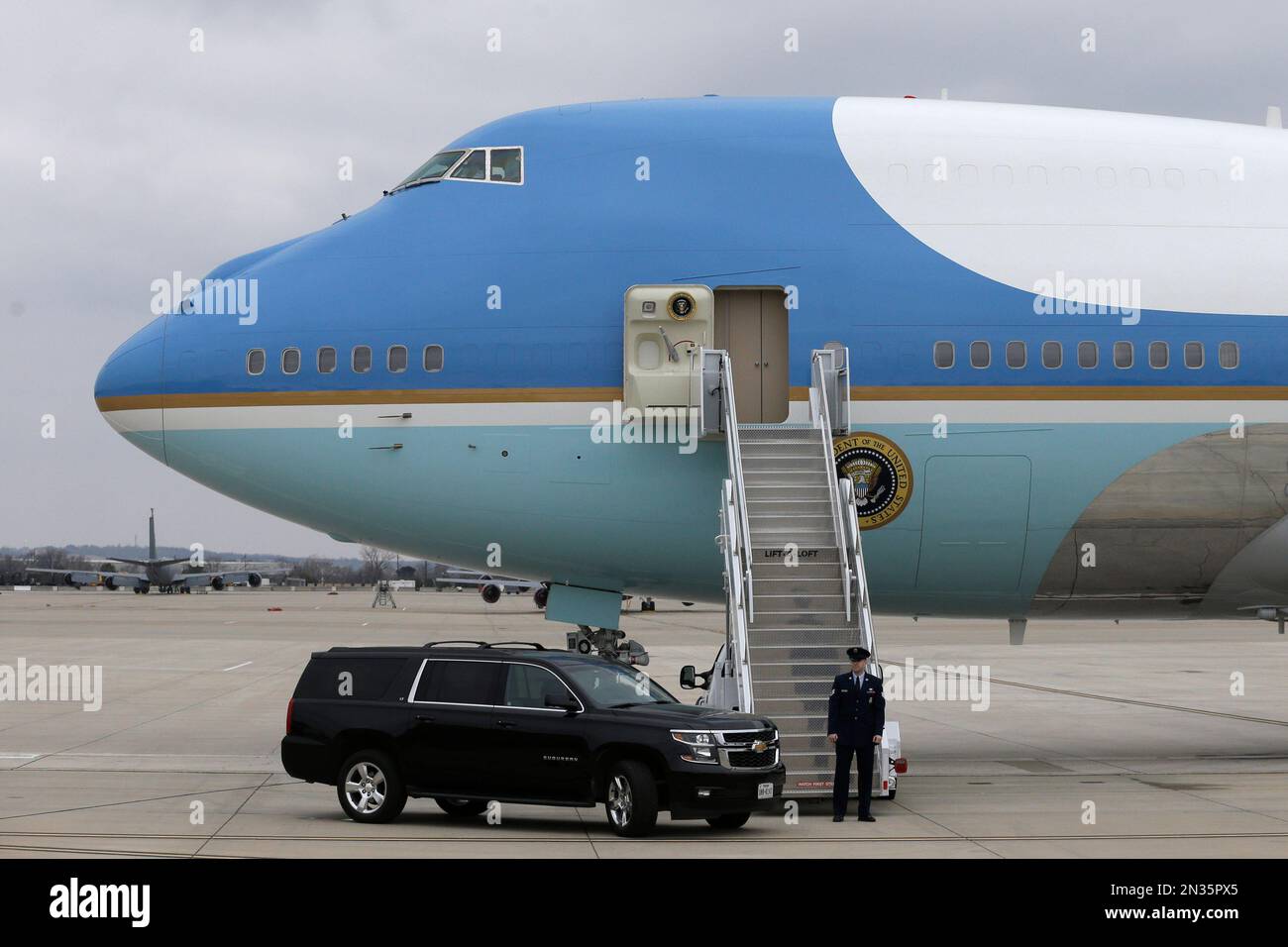 A flight crew member stands guard next to Air Force One at Forbes Field ...