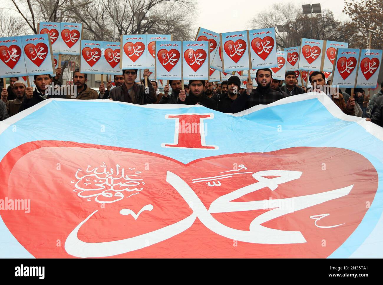 Afghans hold posters that read, "I love Muhammad," during a protest ...