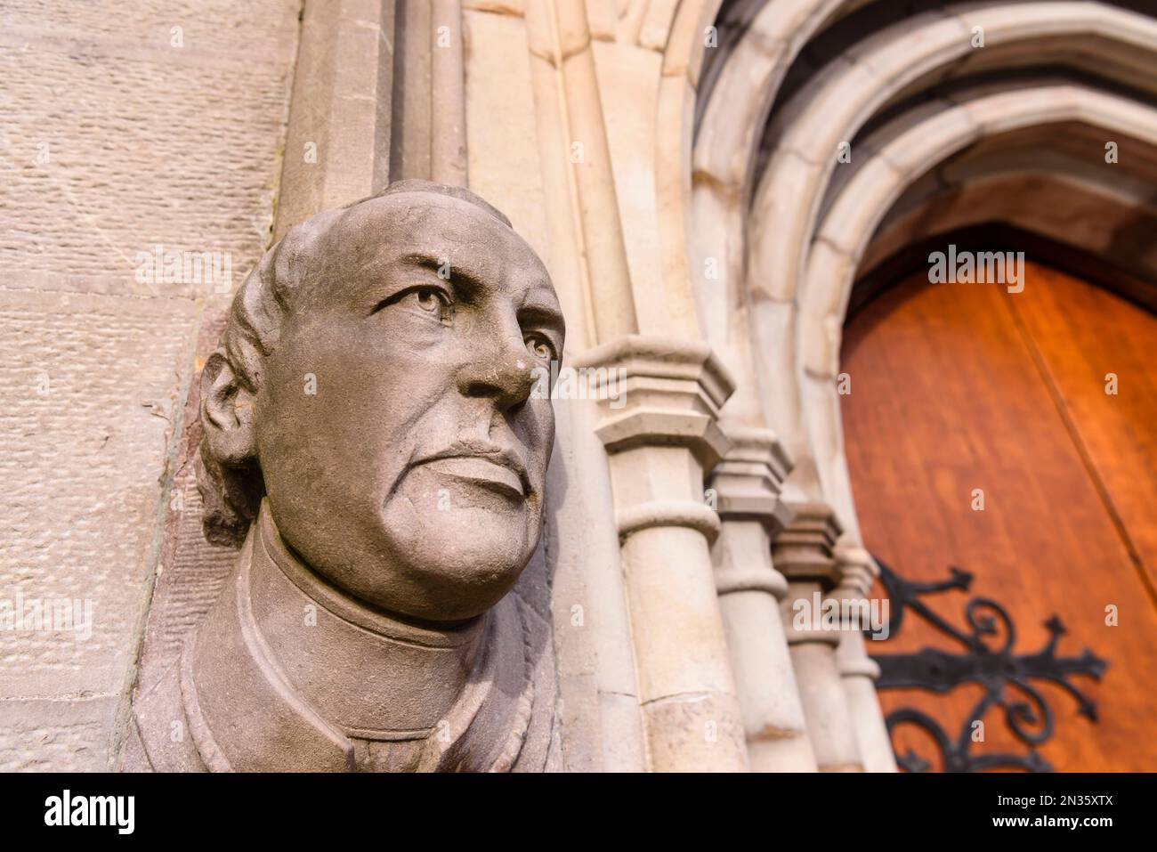 Ornately carved stone head and face on the outside of a church entrance ...