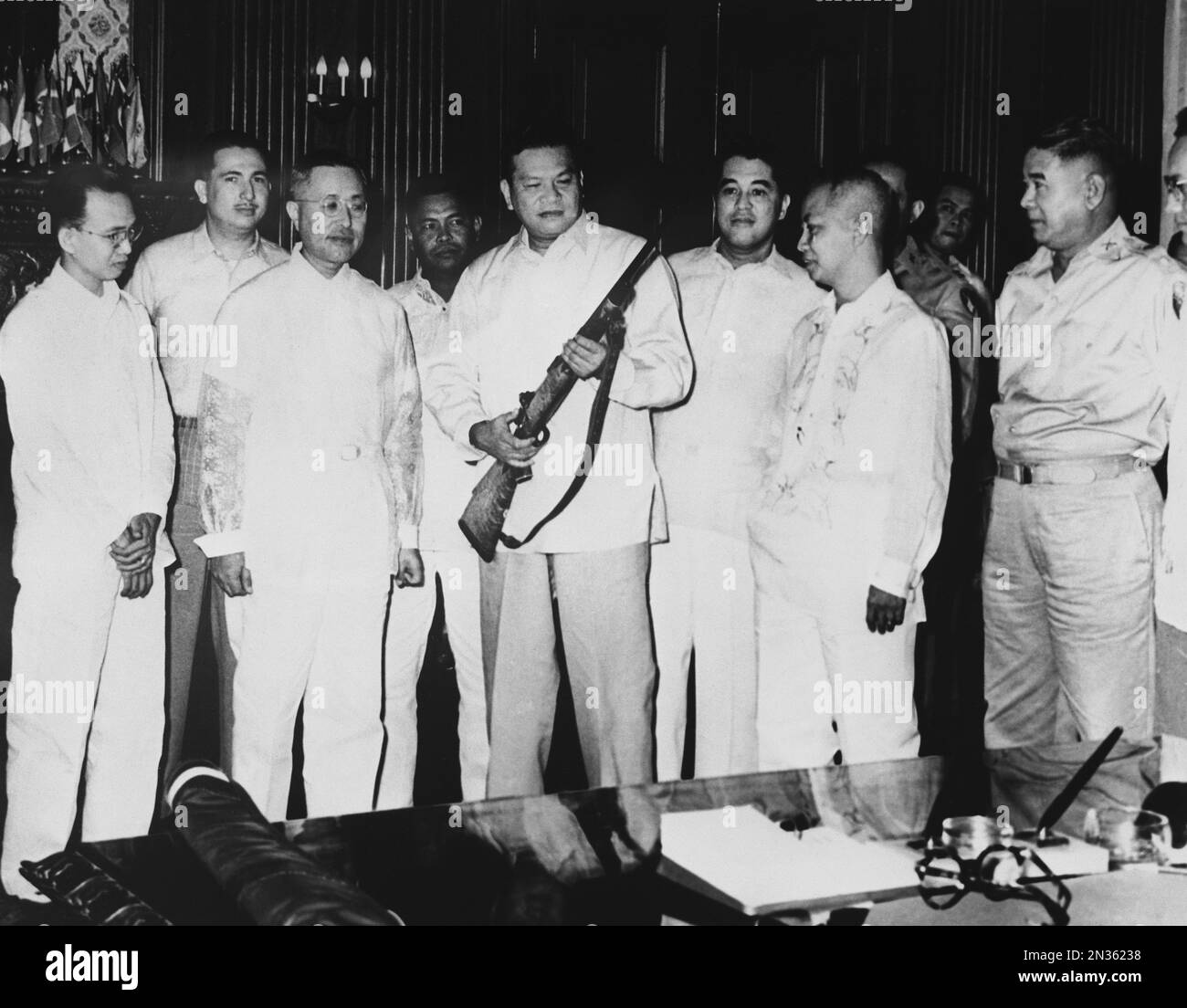 Philippine President Ramon Magsaysay examines a 30-caliber rifle ...