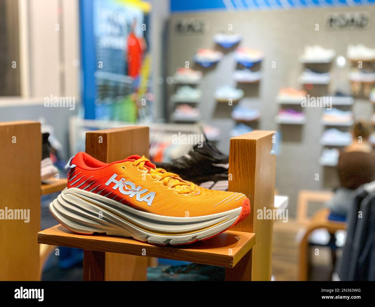 Orange Hoka sneaker on display at the window of their branded store ...