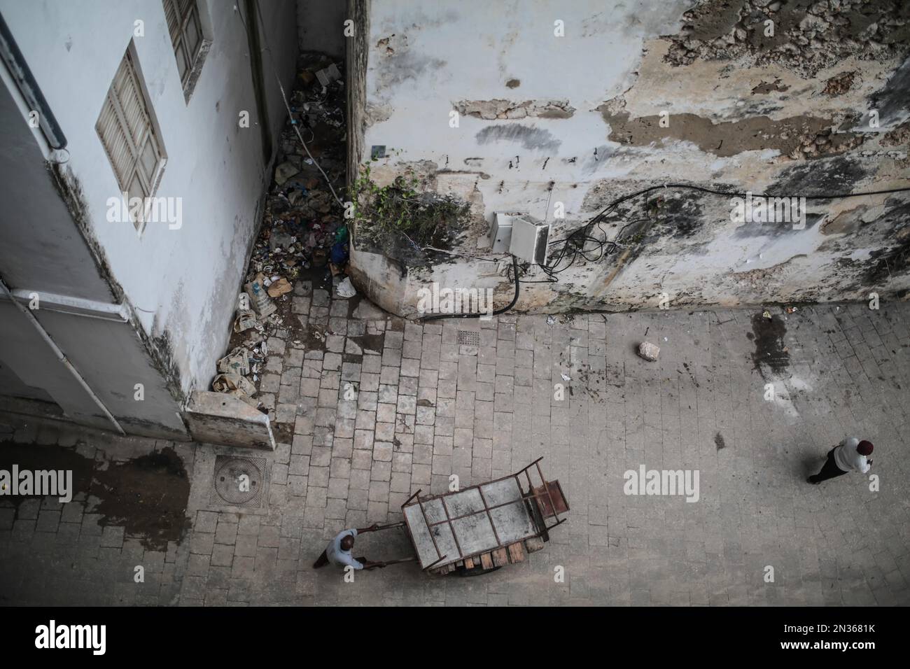 Zanzibaris walk in an alleyway in the historical city of Stone Town ...
