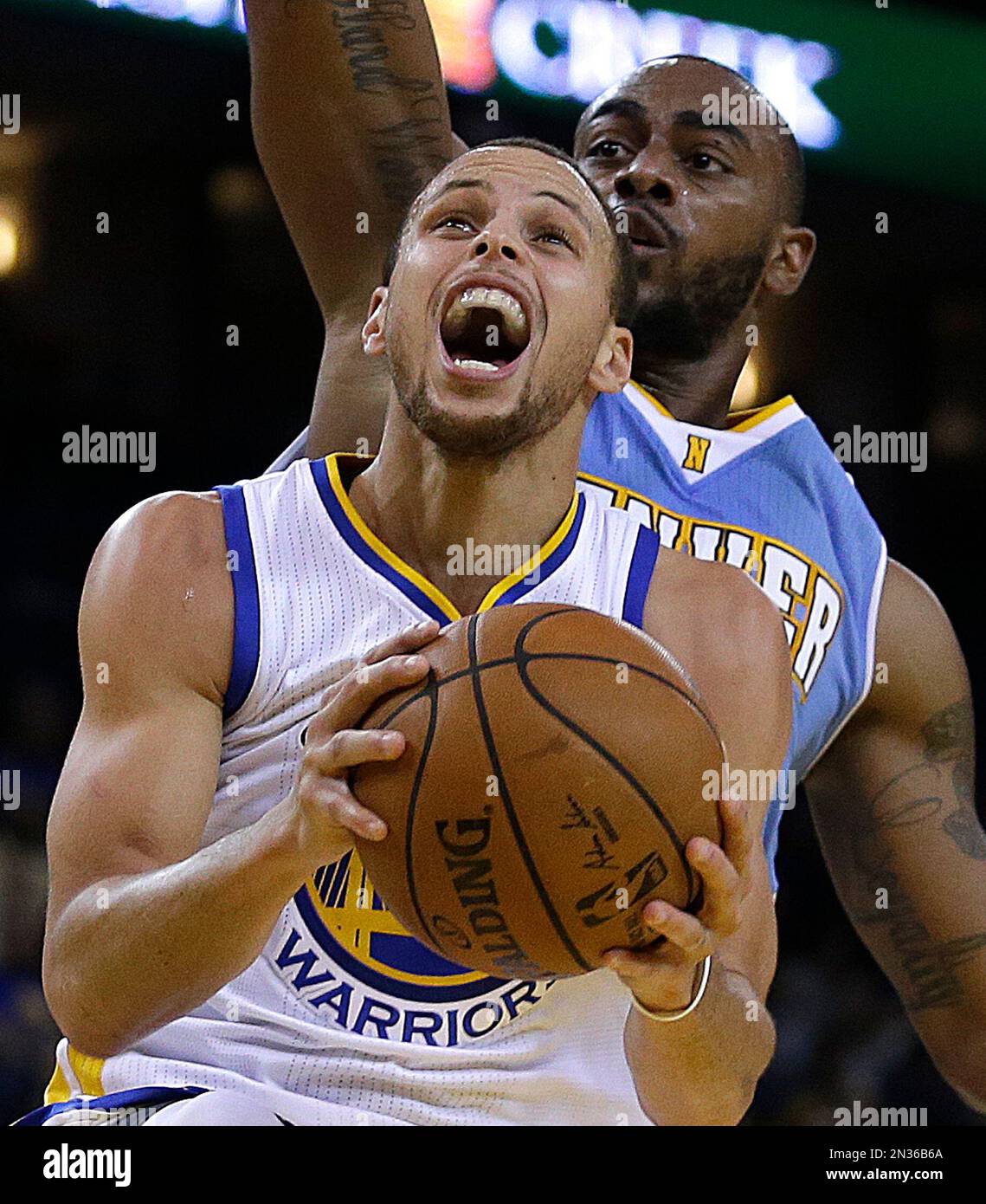 Golden State Warriors' Stephen Curry, left, prepares to shoot past Denver Nuggets' Darrell ...