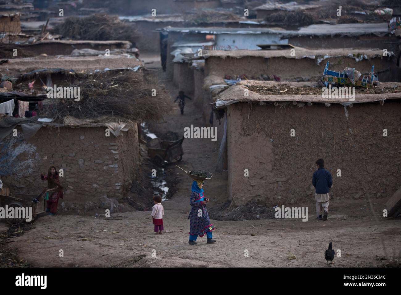 Afghan refugees walk in a slum on the outskirts of Islamabad, Pakistan ...