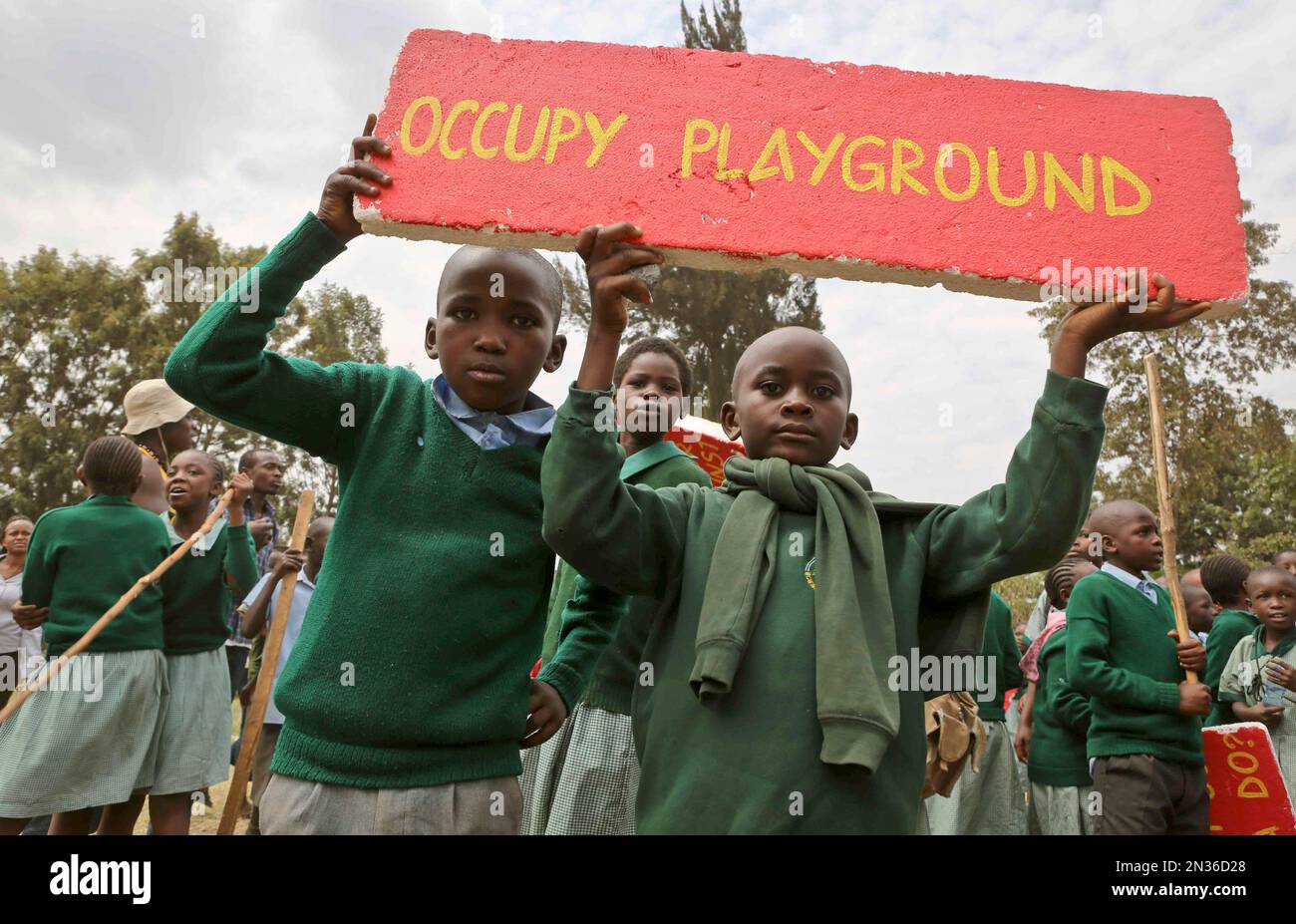 Kenyan school pupils hold up a placard brought by activists during a ...