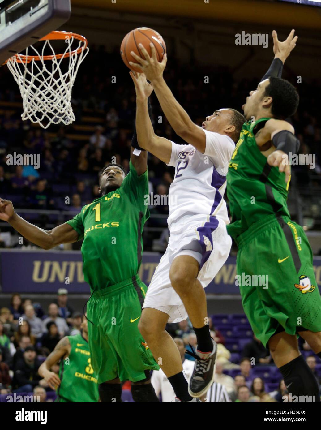 Washington's Andrew Andrews, center, drives to the basket between ...