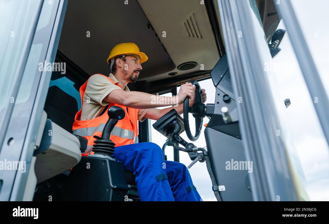 Construction worker on excavator planning the work to be done Stock ...