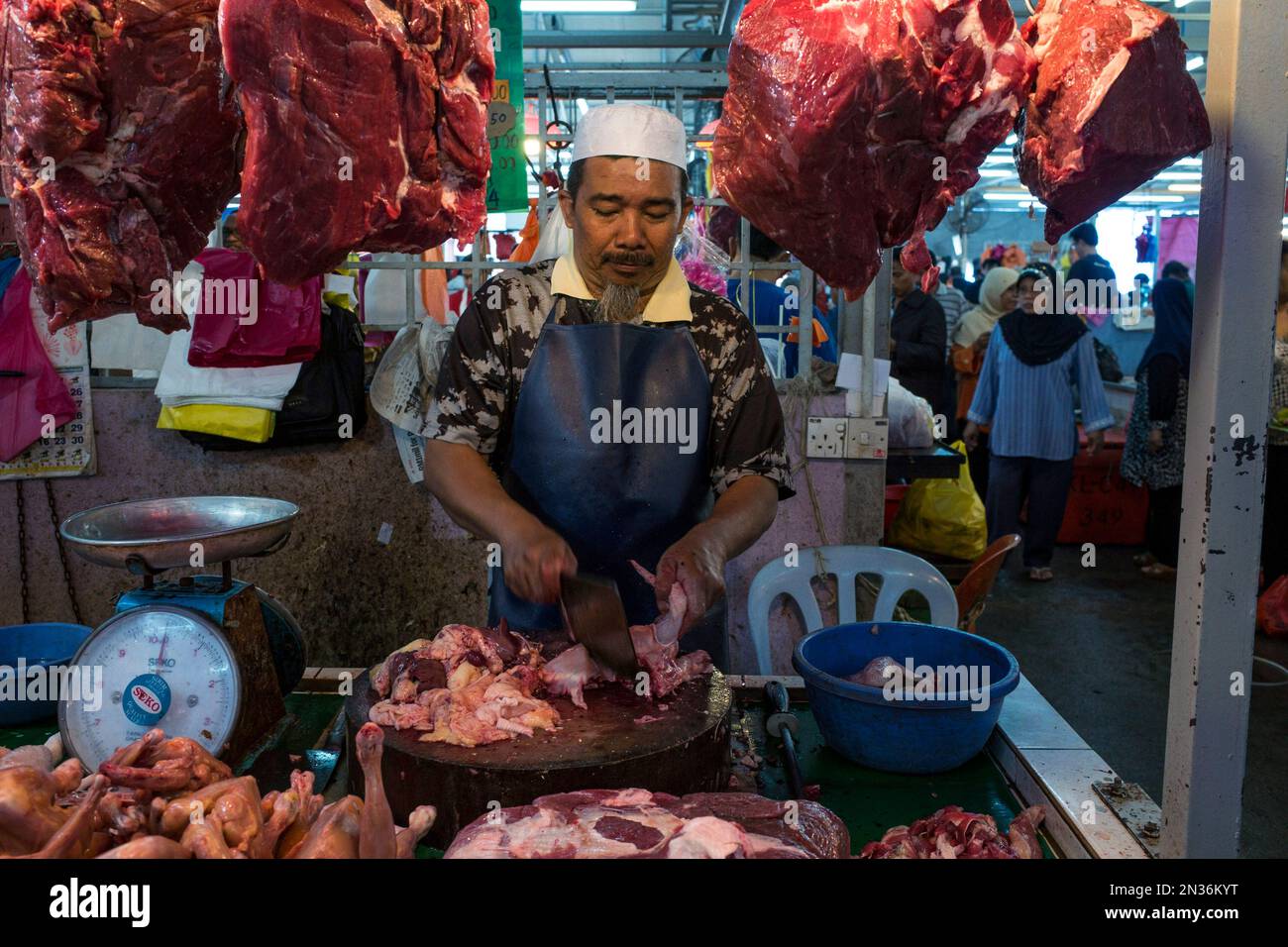 A Malaysian Muslim butcher prepares fresh meat at the Kampung Baru wet ...