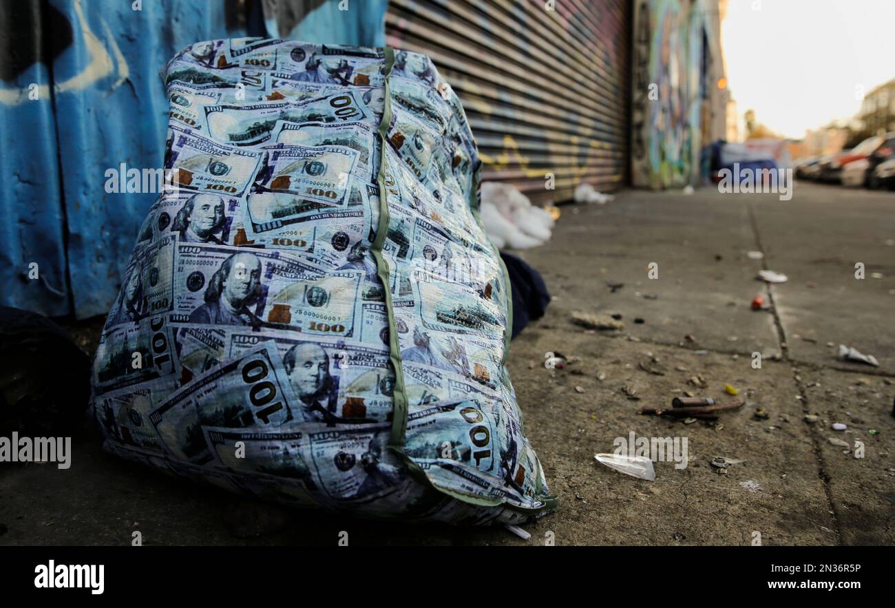 A sack full of discarded clothing, displaying 100 dollar bills has been ...