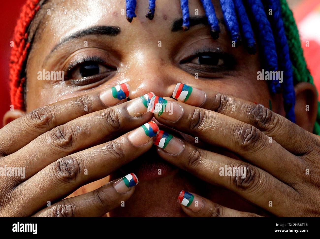 A soccer supporter with Equatorial Guinea colors painted on her nails ...