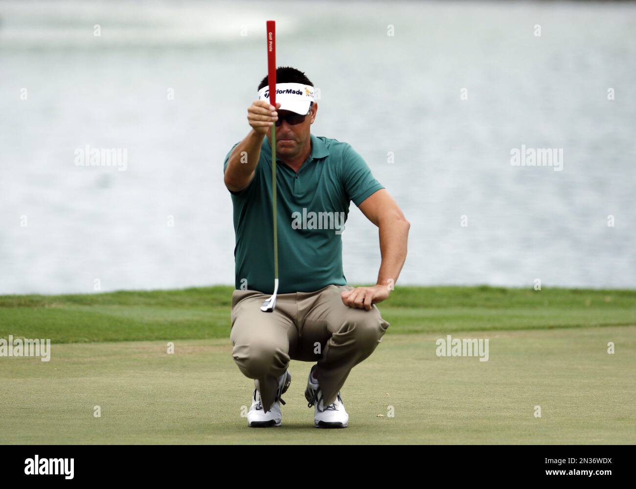 Robert Allenby, of Australia, lines up his ball on the third green ...