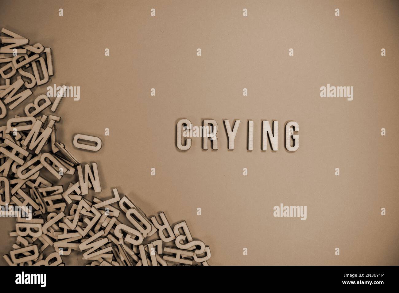 CRYING in wooden English language capital letters spilling from a pile ...