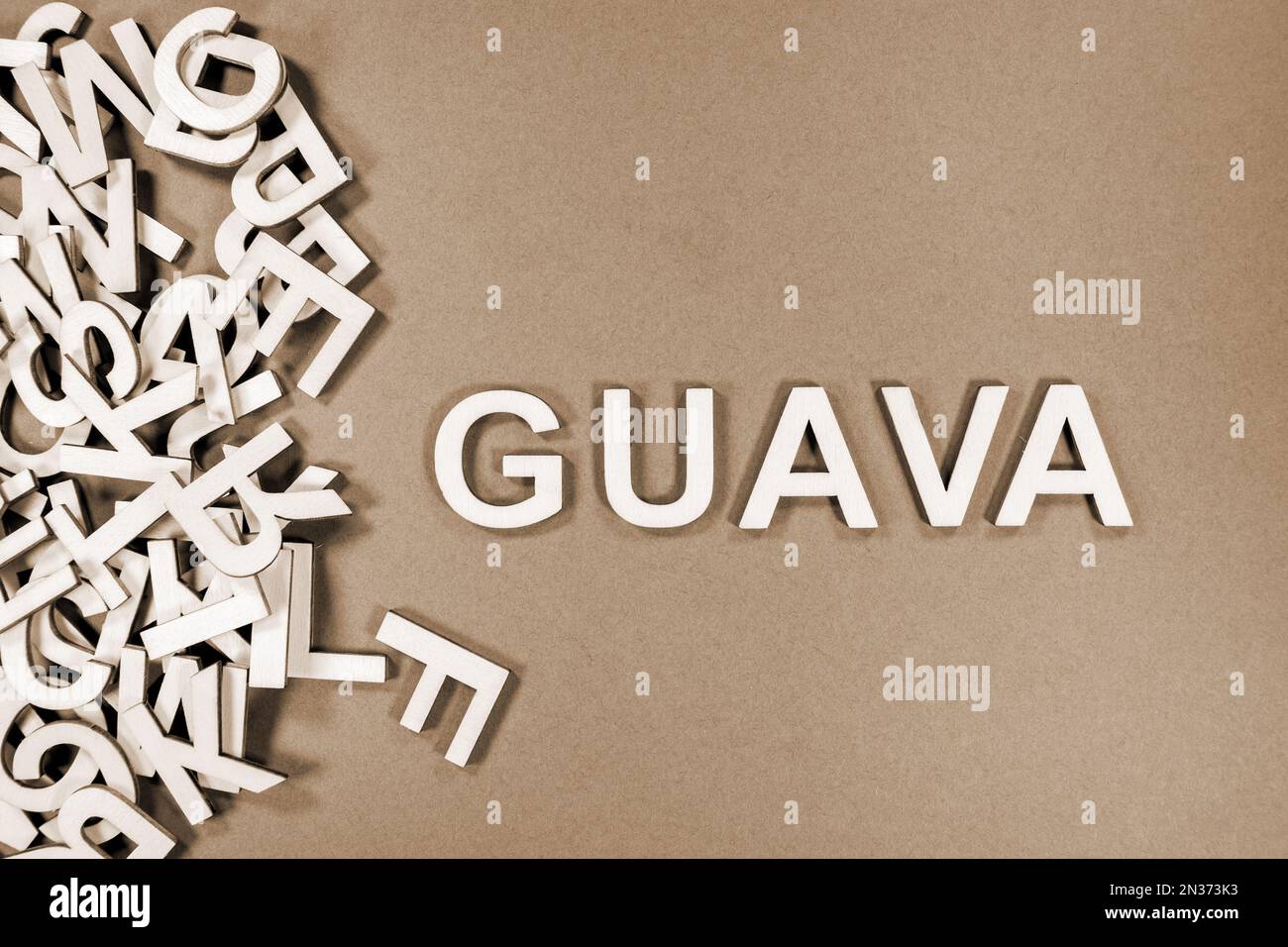 GUAVA in wooden English language capital letters spilling from a pile ...