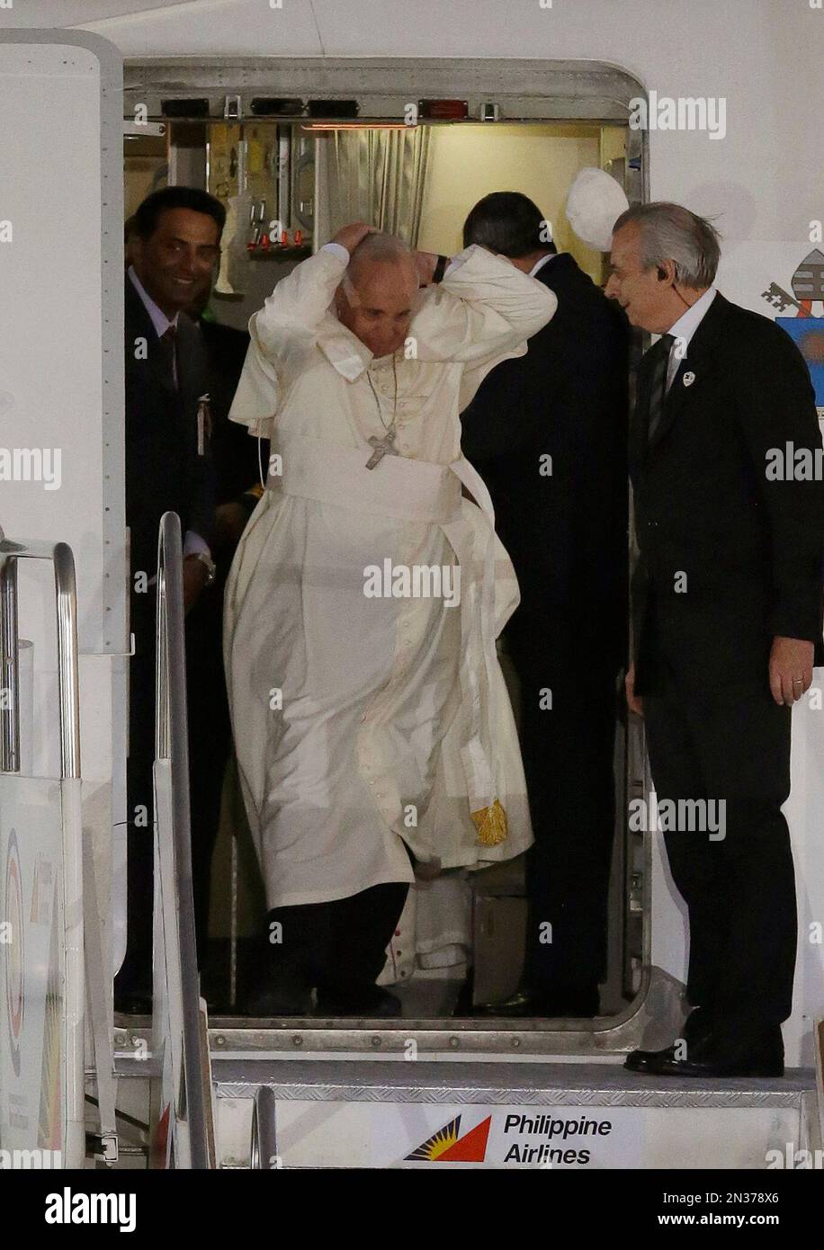 Pope Francis loses his skull cap as he disembarks from his plane upon ...