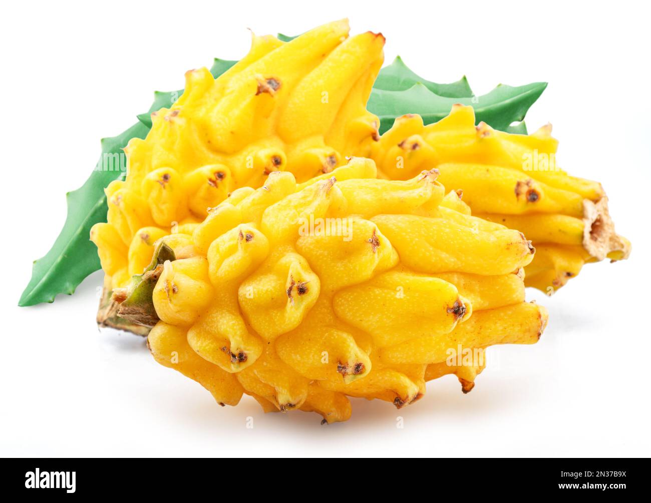 Yellow dragon fruits with green leaves isolated on white background ...