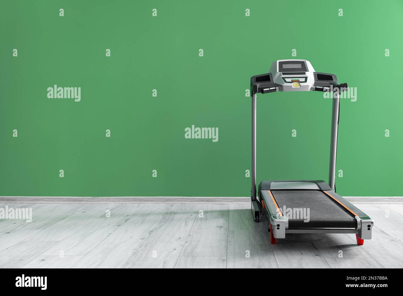 Modern treadmill near green wall Stock Photo - Alamy