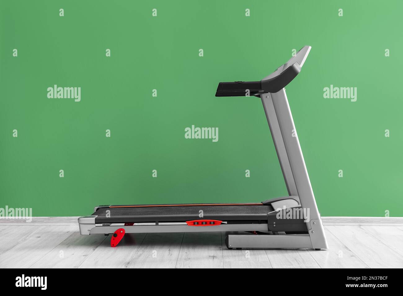 Modern treadmill near green wall Stock Photo - Alamy