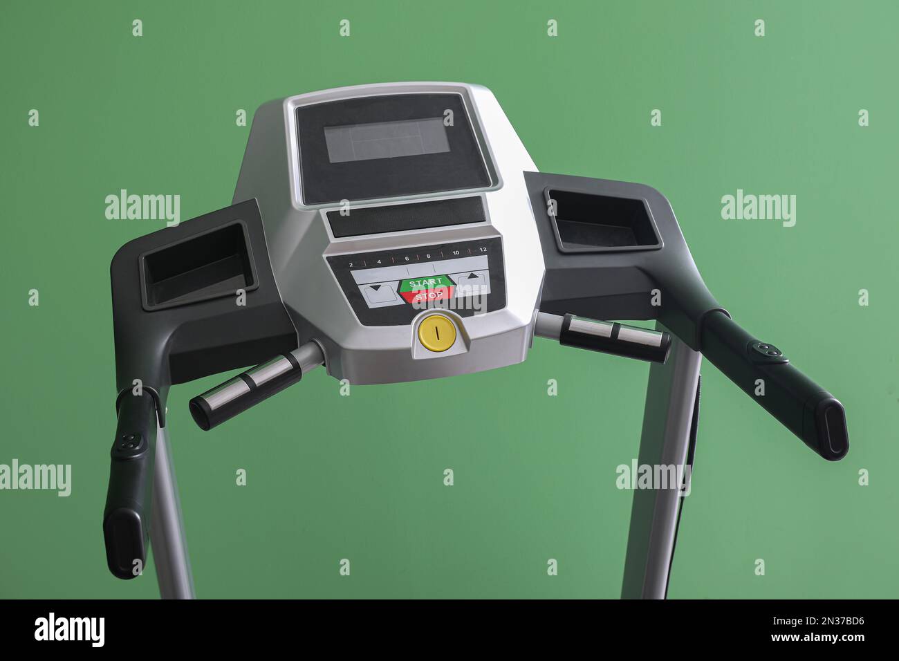Modern treadmill near green wall, closeup Stock Photo - Alamy