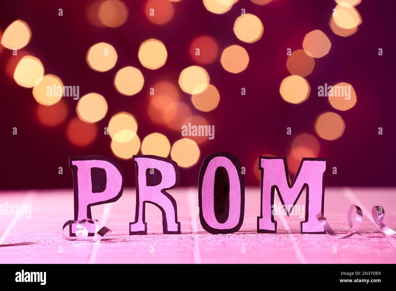 Word PROM and serpentine on table against blurred lights Stock Photo ...